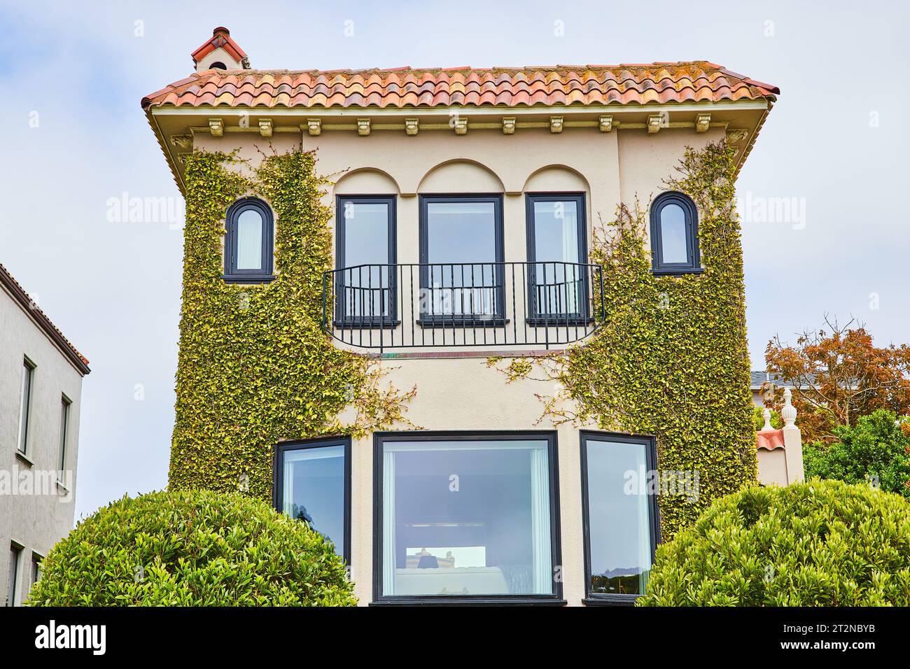 Both sides of house covered in creeping vines and circular tops of ...