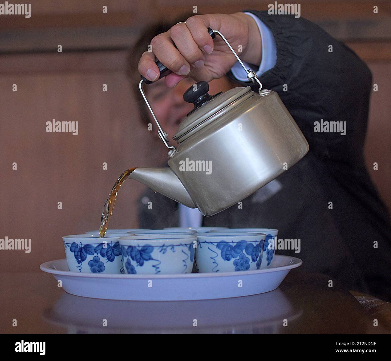 Japanese man serving tea with a kettle Stock Photo - Alamy