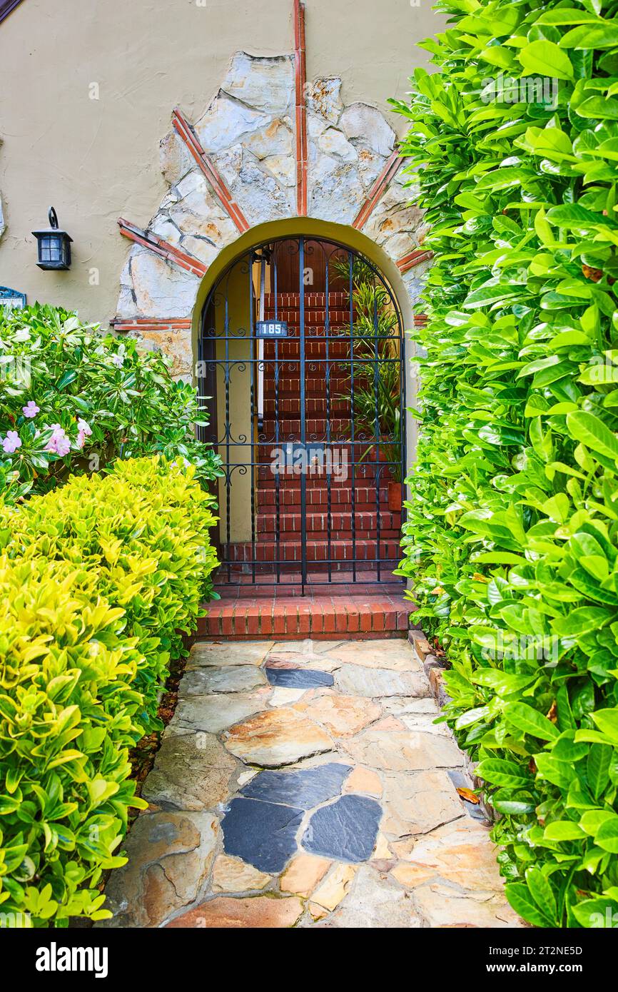 Sidewalk leading to gated stone arch entry of San Francisco home lined ...