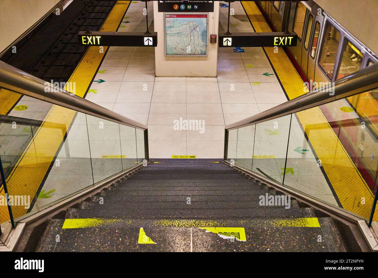 Stairs leading down to subway with exit signs and map of area on board ...