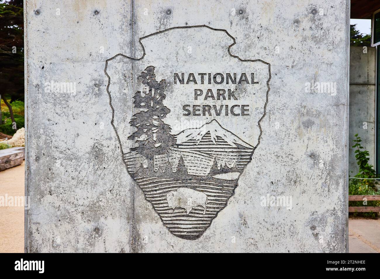 Embedded National Park Service logo on textured concrete wall framed by ...