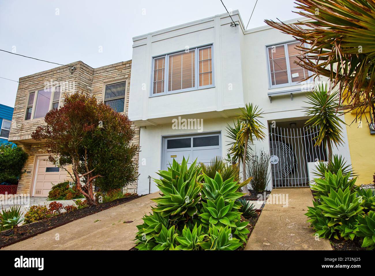 Compact white house with garage beside gated front door with swirl ...