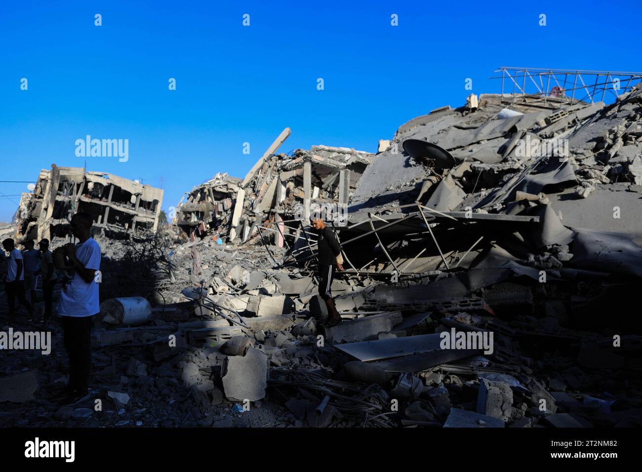 Gaza. 20th Oct, 2023. People stand in front of buildings destroyed in ...