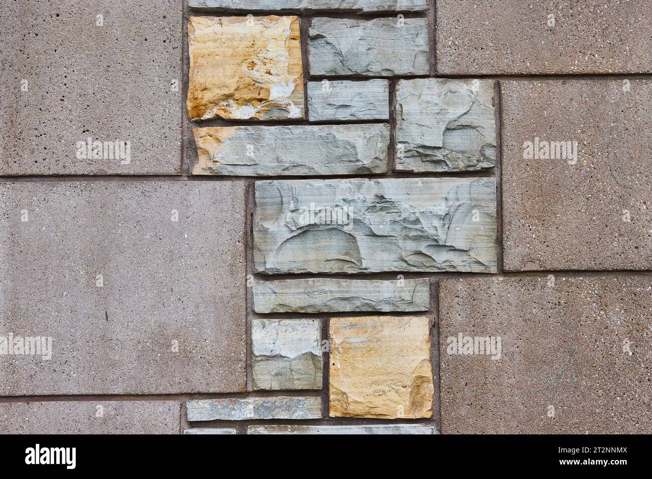 Vertical concrete wall with textured silver and gold stones in ...