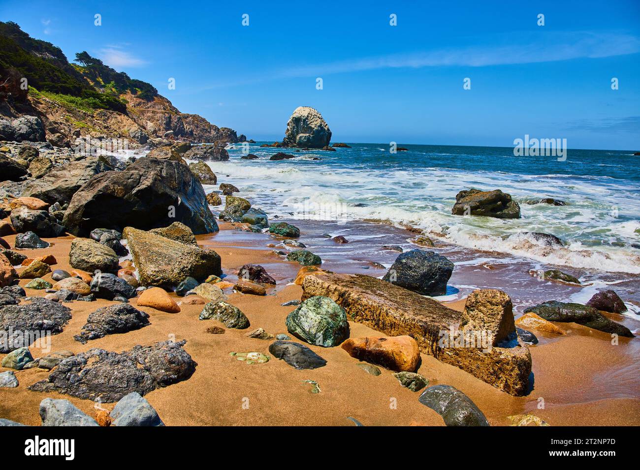 Inspirational ocean view with pebble strewn beach along rocky coast on ...