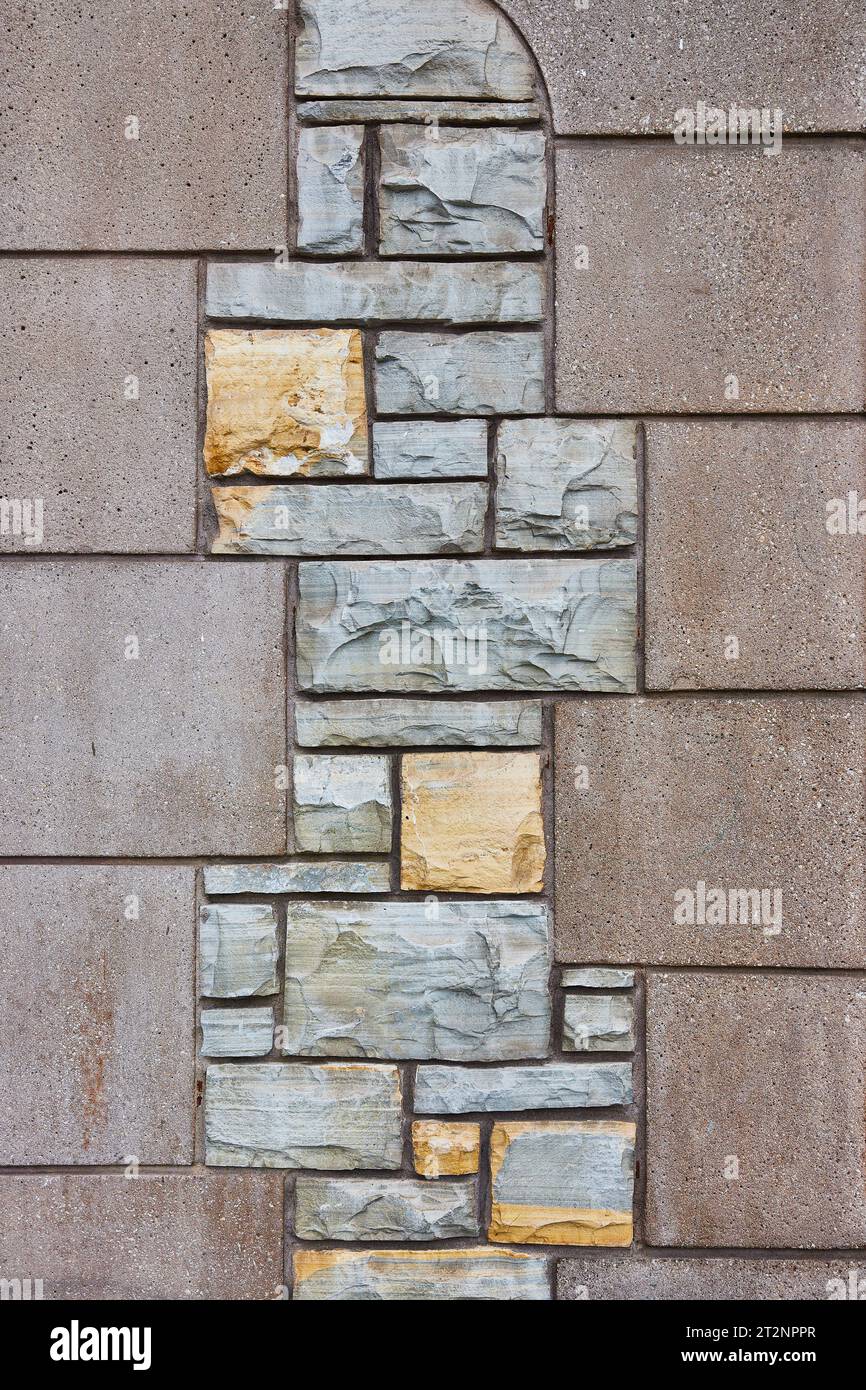 Vertical wall of concrete with river of textured silver and gold stones ...