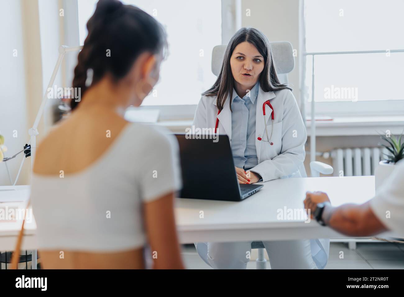 An experienced doctor advises a couple at a health clinic, discussing ...