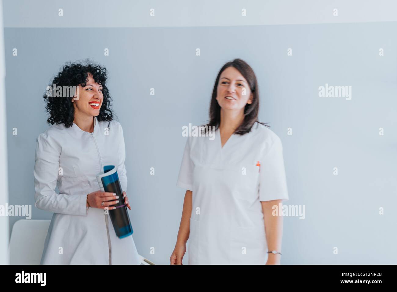 Two doctors, females, having fun conversation at the hospital during ...