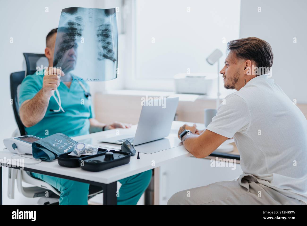 Doctor analyzing x-ray film, discussing diagnosis and treatment options ...