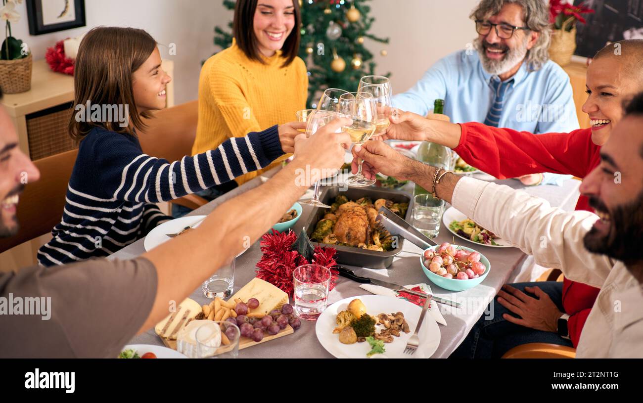Cheers laughing family celebrating Christmas meal together toasting ...