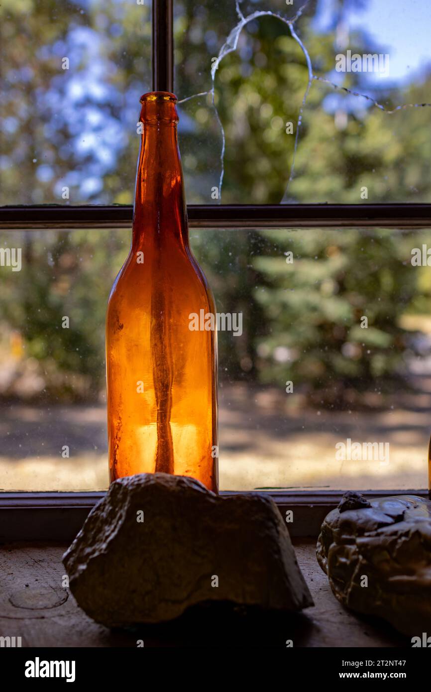 Vintage Amber beer bottle on a window sill in background the window has ...