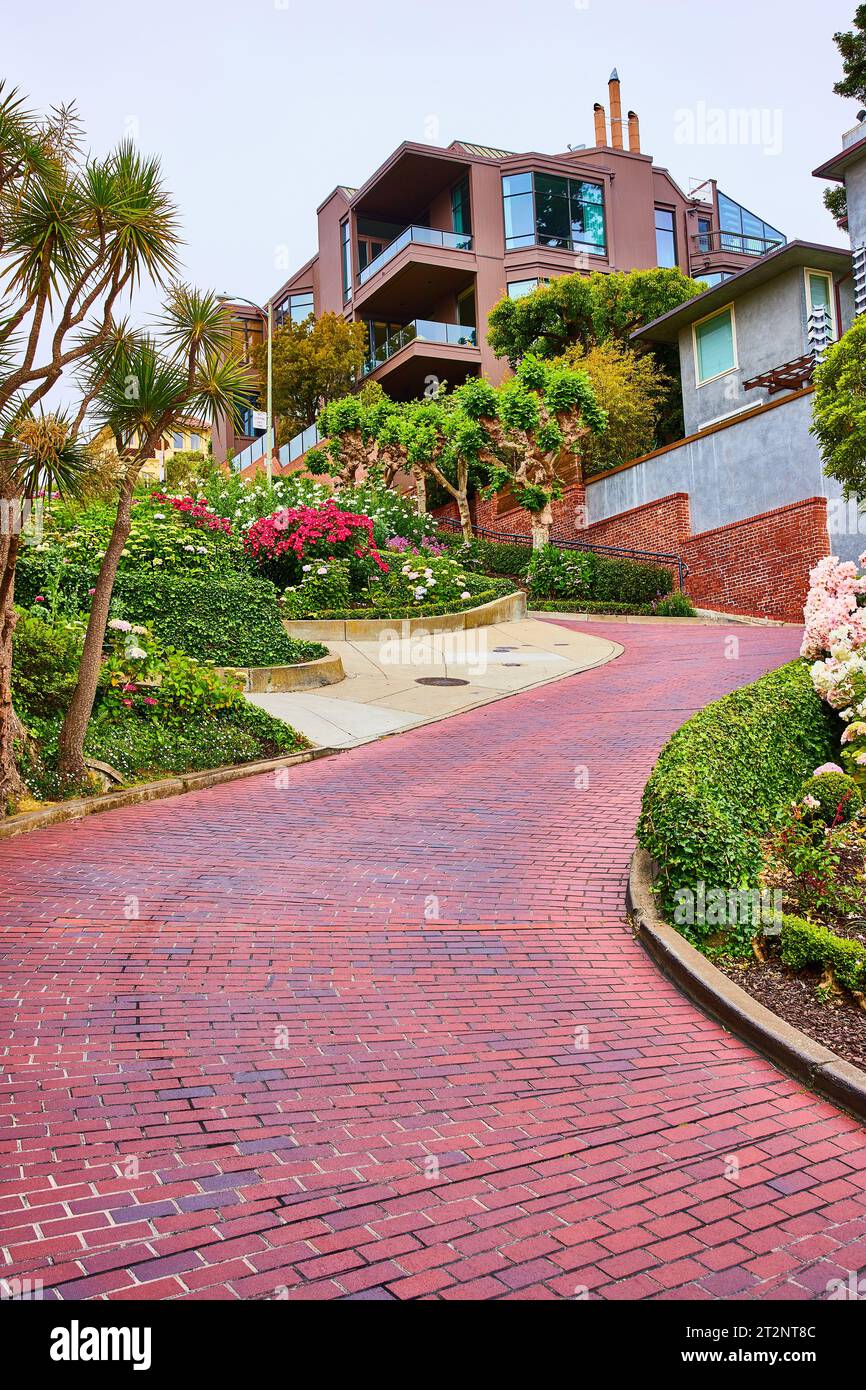 Empty curving red brick road with large brown mansion at top Stock ...