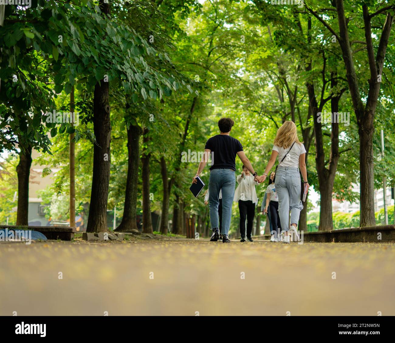 School couple holding hands hanging out after classes. Low angle view ...