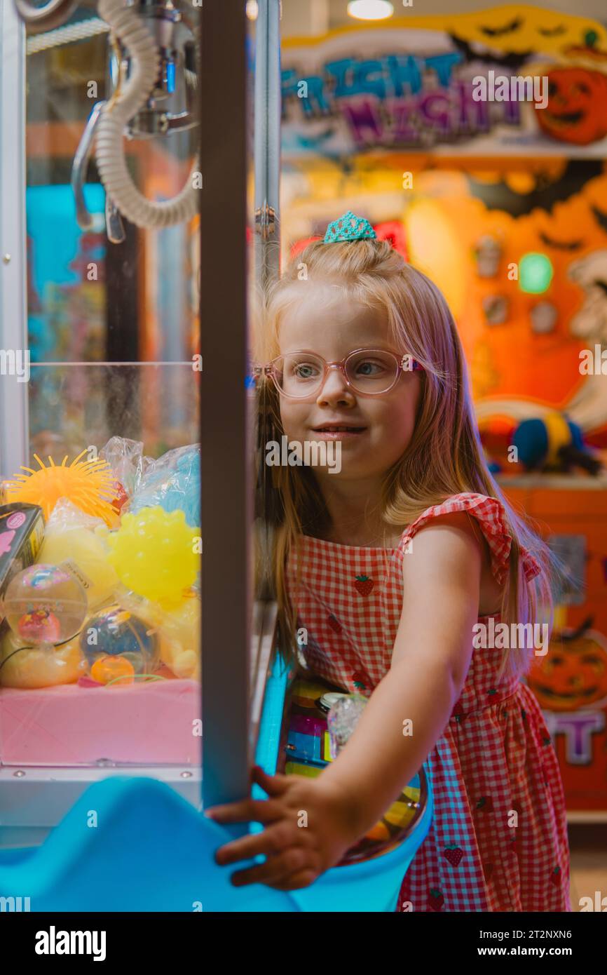 Little girl hugging claw machine Stock Photo - Alamy