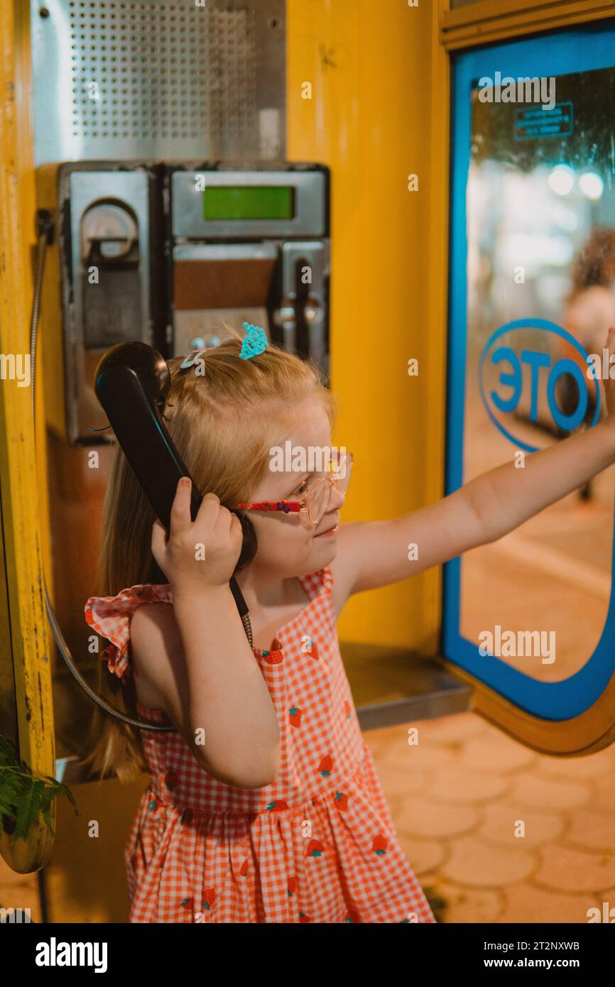 Little girl on a retro phone booth Stock Photo - Alamy