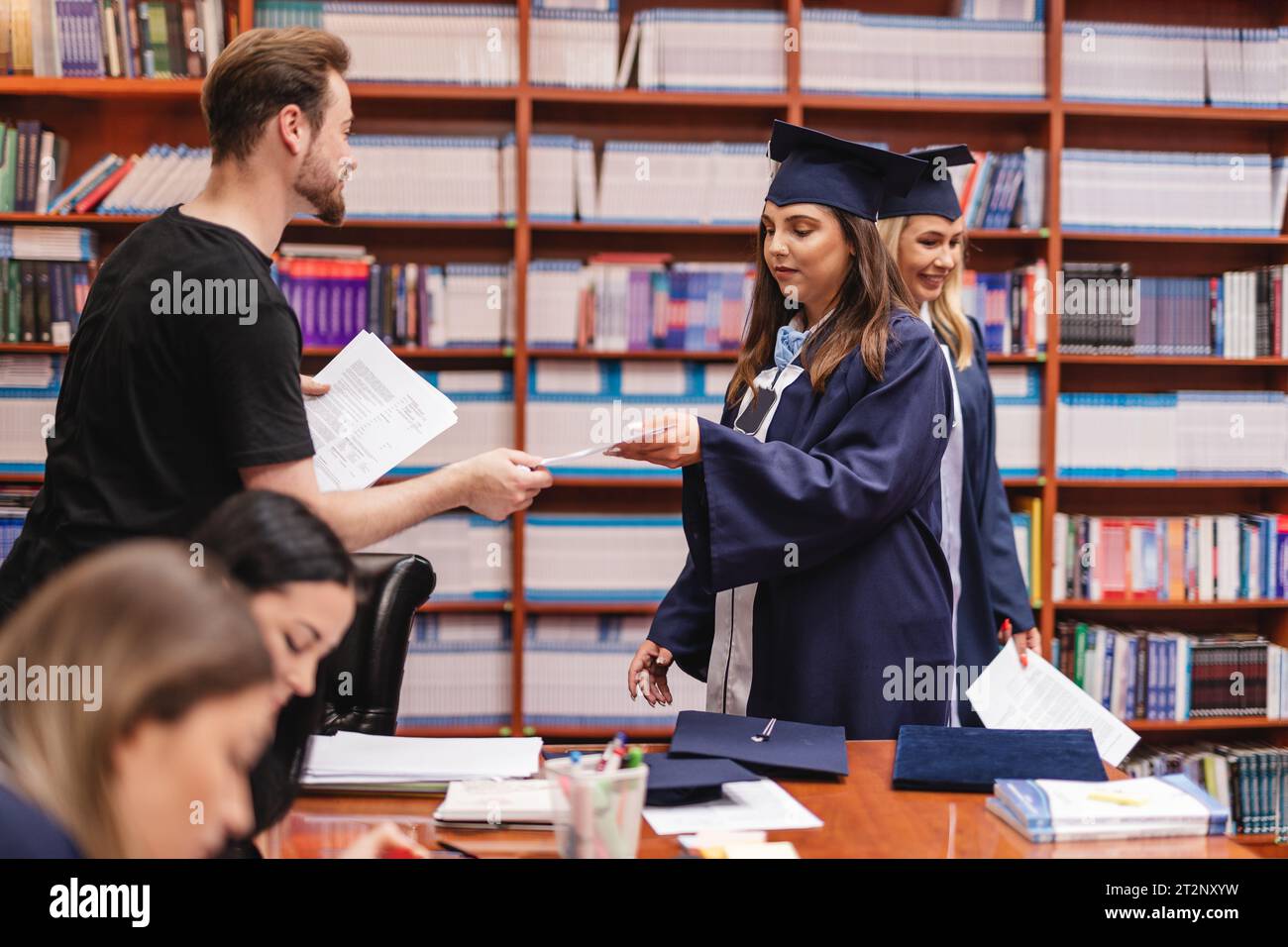 Group of faculty students writing graduation forums Stock Photo - Alamy