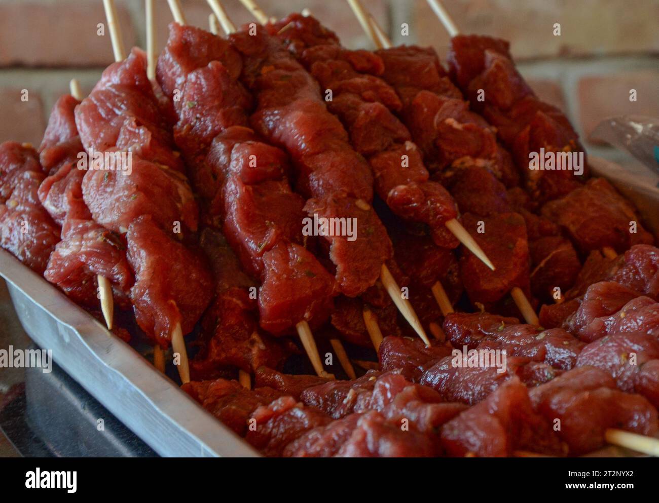 Beef chopped into cubes, skewered on a bamboo stick, seasoned to be ...