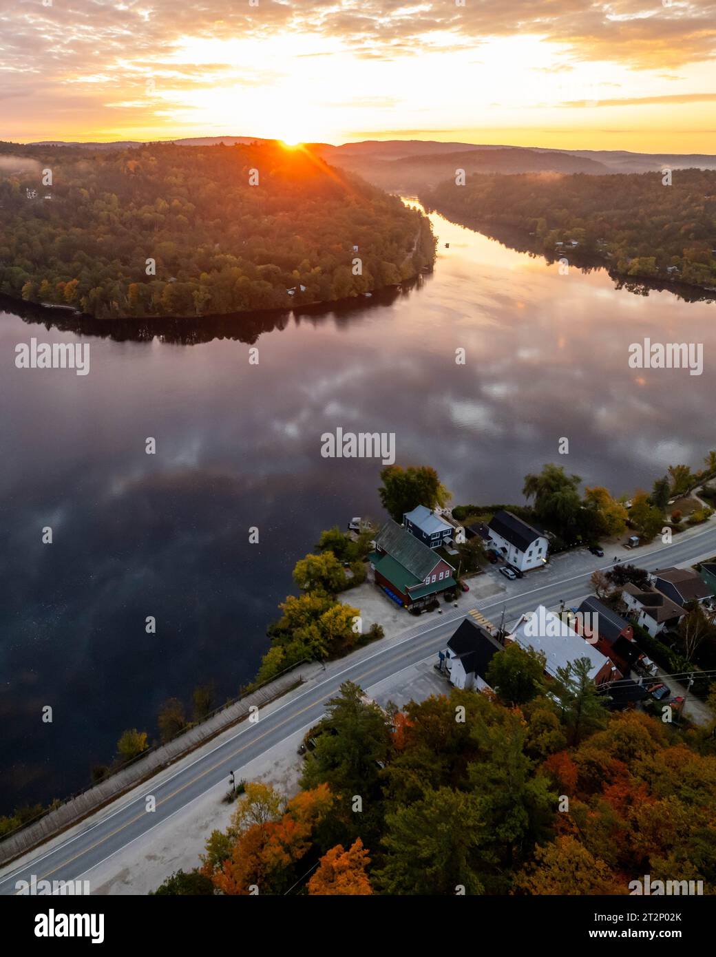 An aerial of the beautiful sunset shining over a village behind the ...