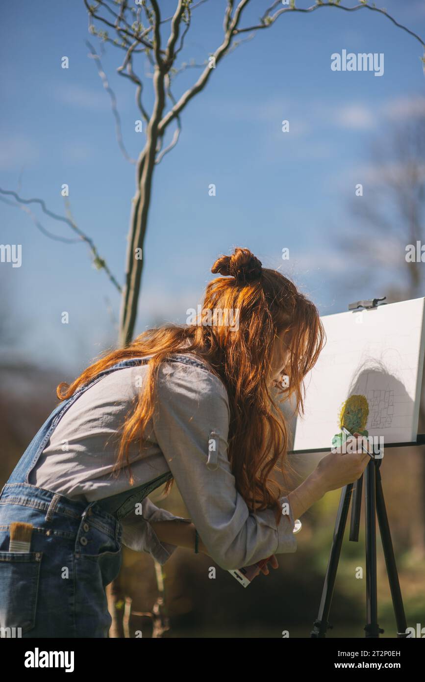 Female artist painting on an easel Stock Photo - Alamy