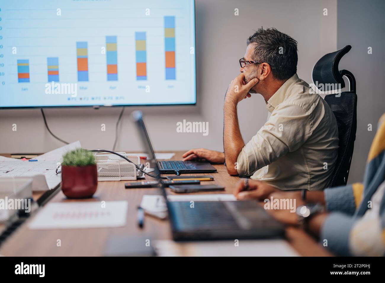 Collaborative business meeting discussing architectural blueprints and ...