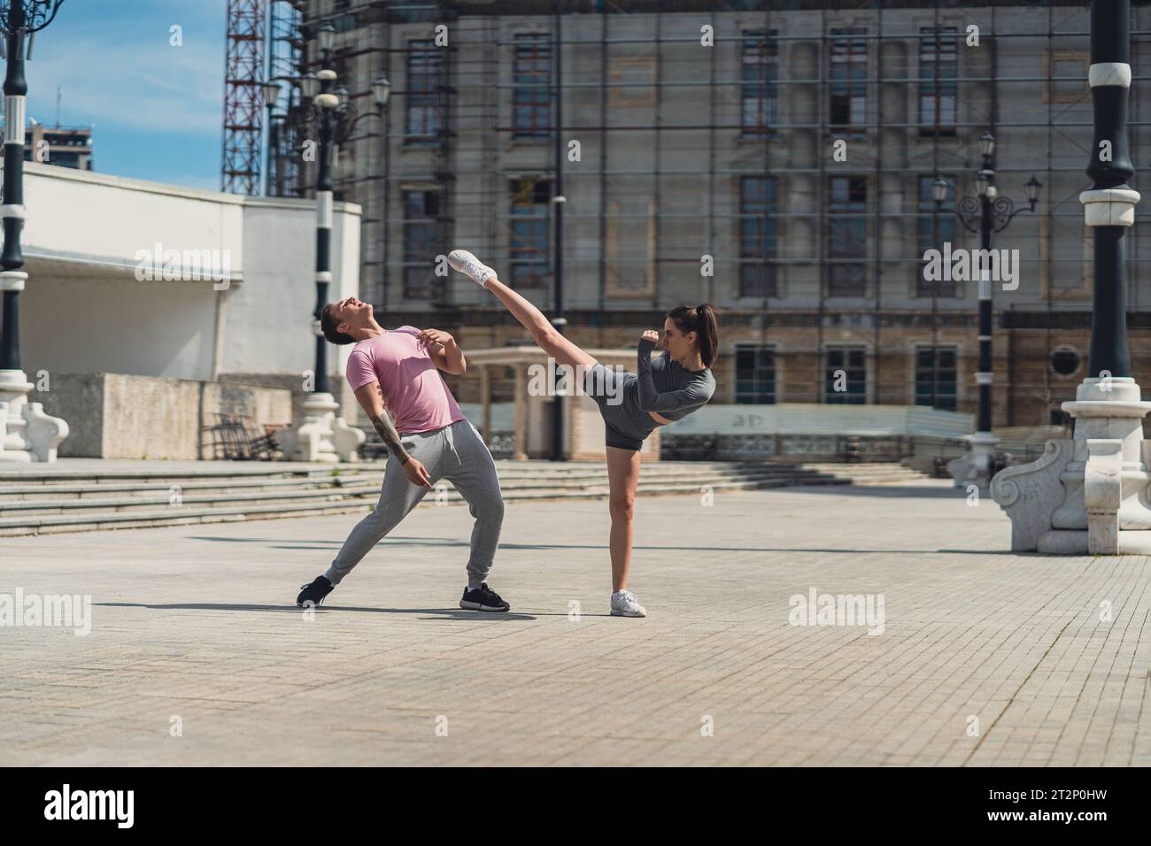 Flexible female kickboxer kick her male friend in a head with her leg ...