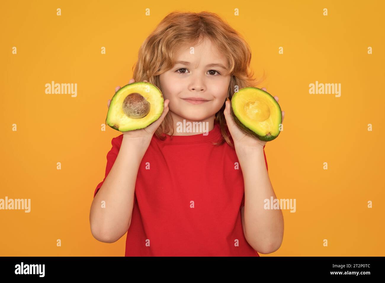Healthy fruits and vegetables for kids. Kid hold red avocado in studio ...