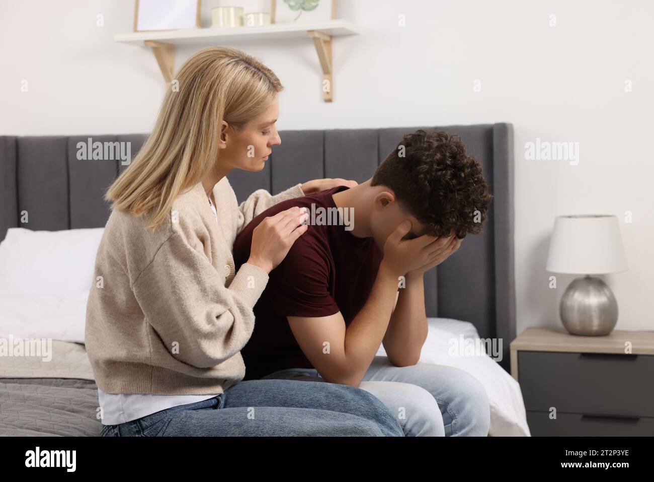 Mother consoling her upset son in bedroom. Teenager problems Stock ...