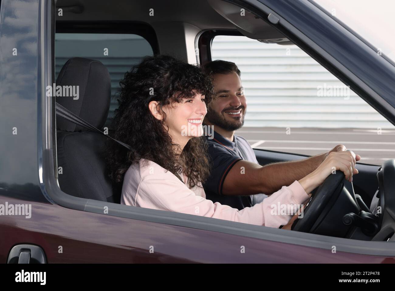 Driving school. Happy student during lesson with driving instructor in ...