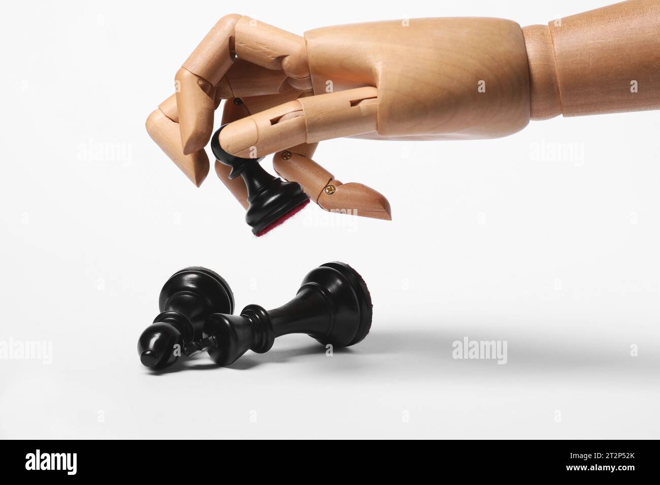 Robot holding pawn over other chess pieces on white background. Wooden ...