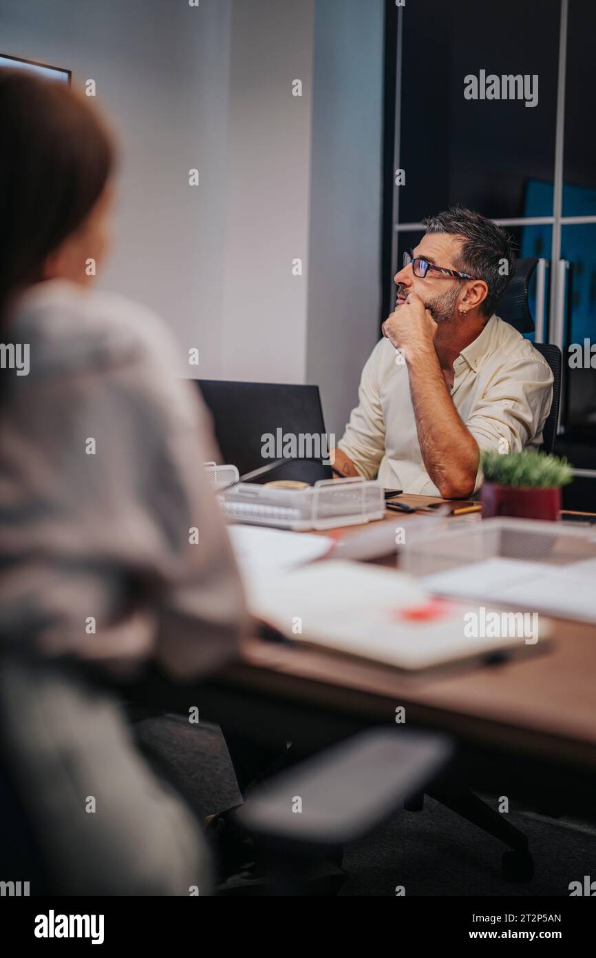 Multiracial executives and engineers collaborate in a conference room, discussing architectural ...