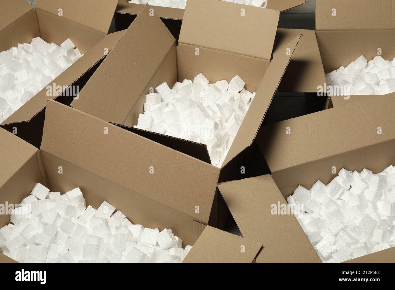 Open cardboard boxes with pieces of polystyrene foam on floor ...