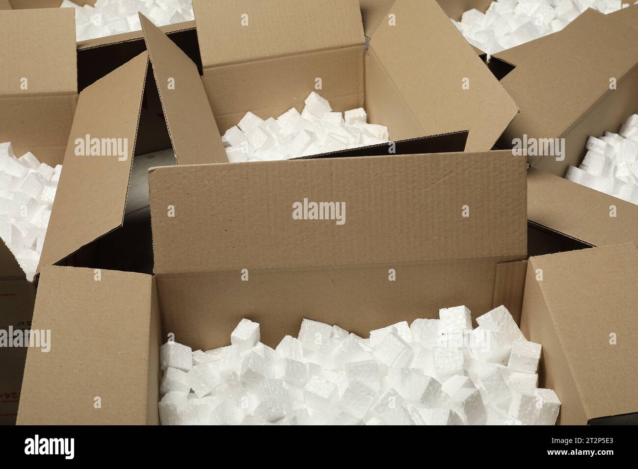 Open cardboard boxes with pieces of polystyrene foam on floor ...