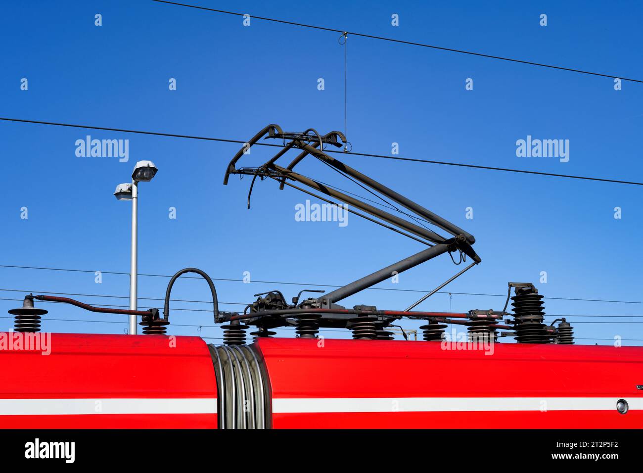 close-up of a pantograph of a red commuter train in cologne against a ...