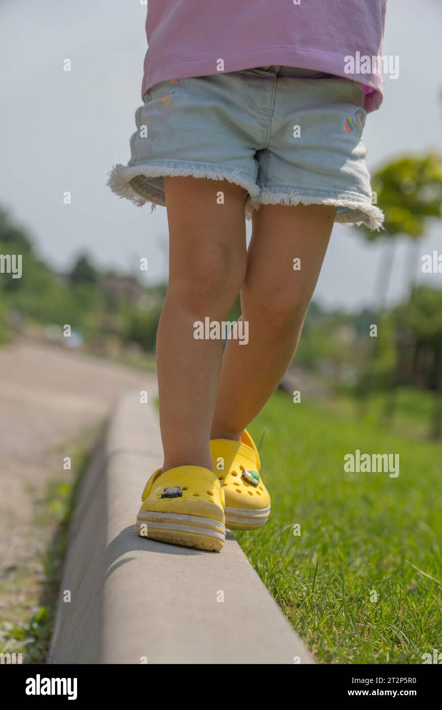 Little kid's legs walking on a sidewalk at park Stock Photo - Alamy