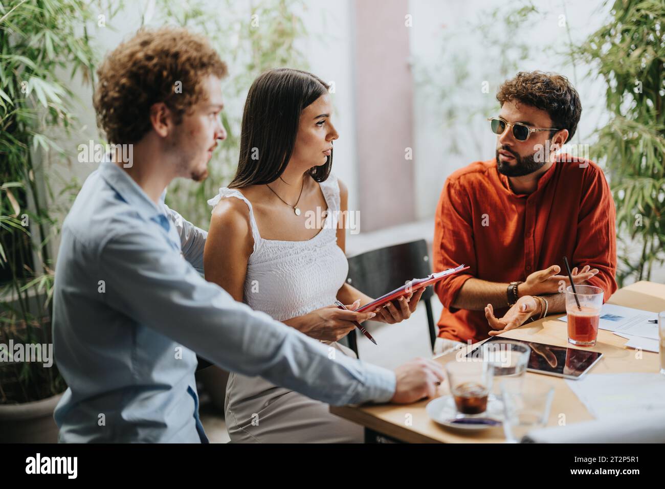 Architects, engineers, and executives discuss blueprints at a coffee ...