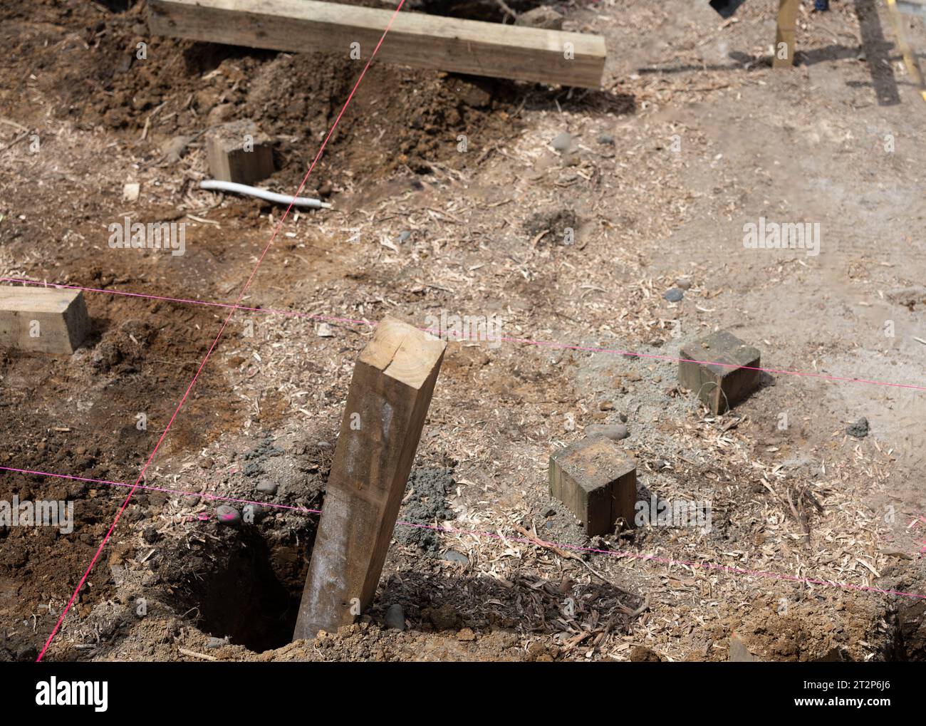 Pink string-lines cross on building site at early stage of setting up ...