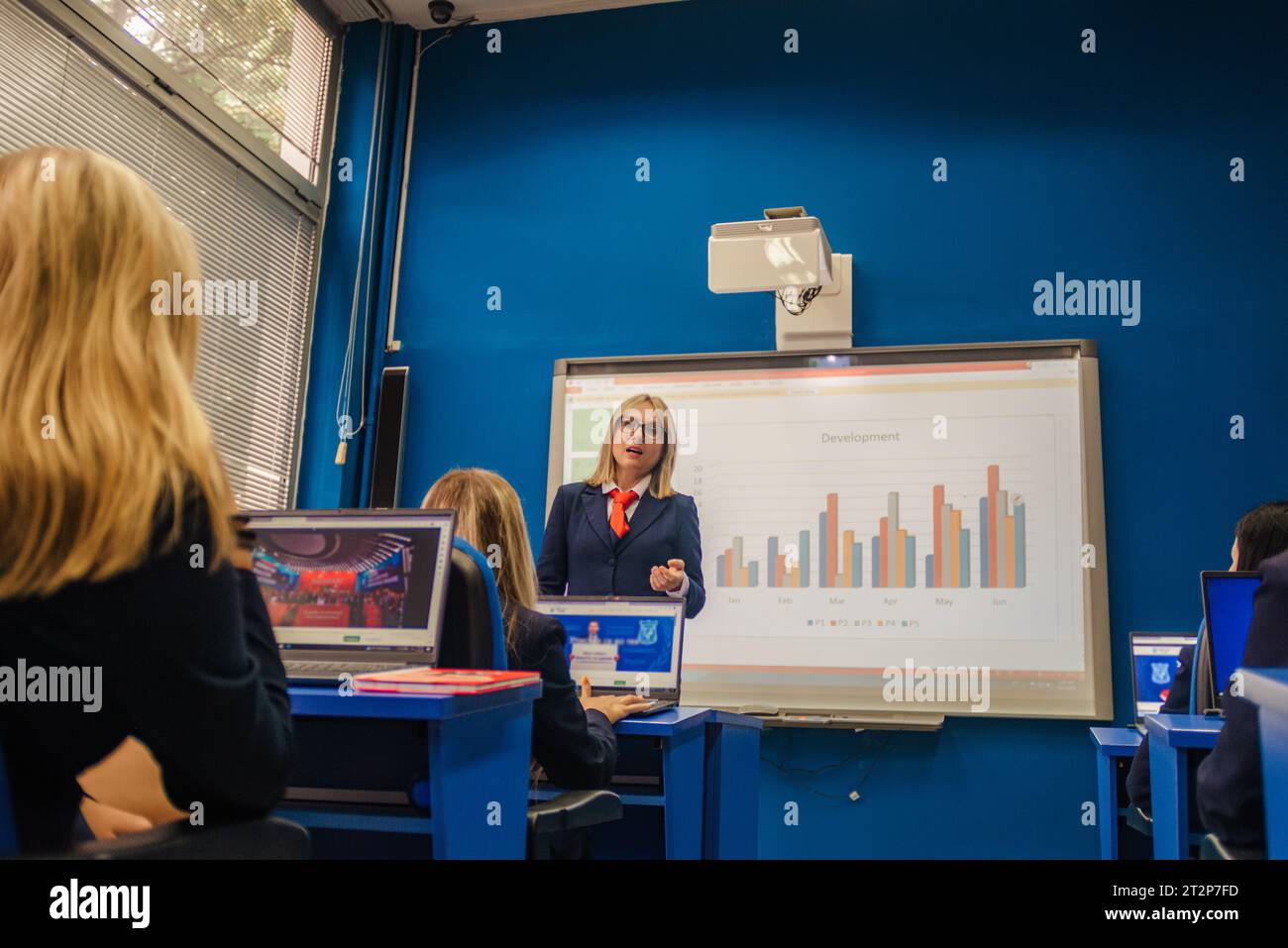 Adult female teacher lecturing the students in the classroom Stock ...