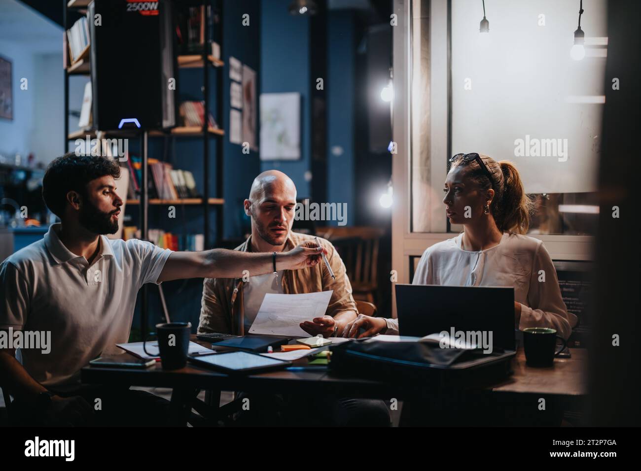 Business partners discuss project details and review paperwork in a ...
