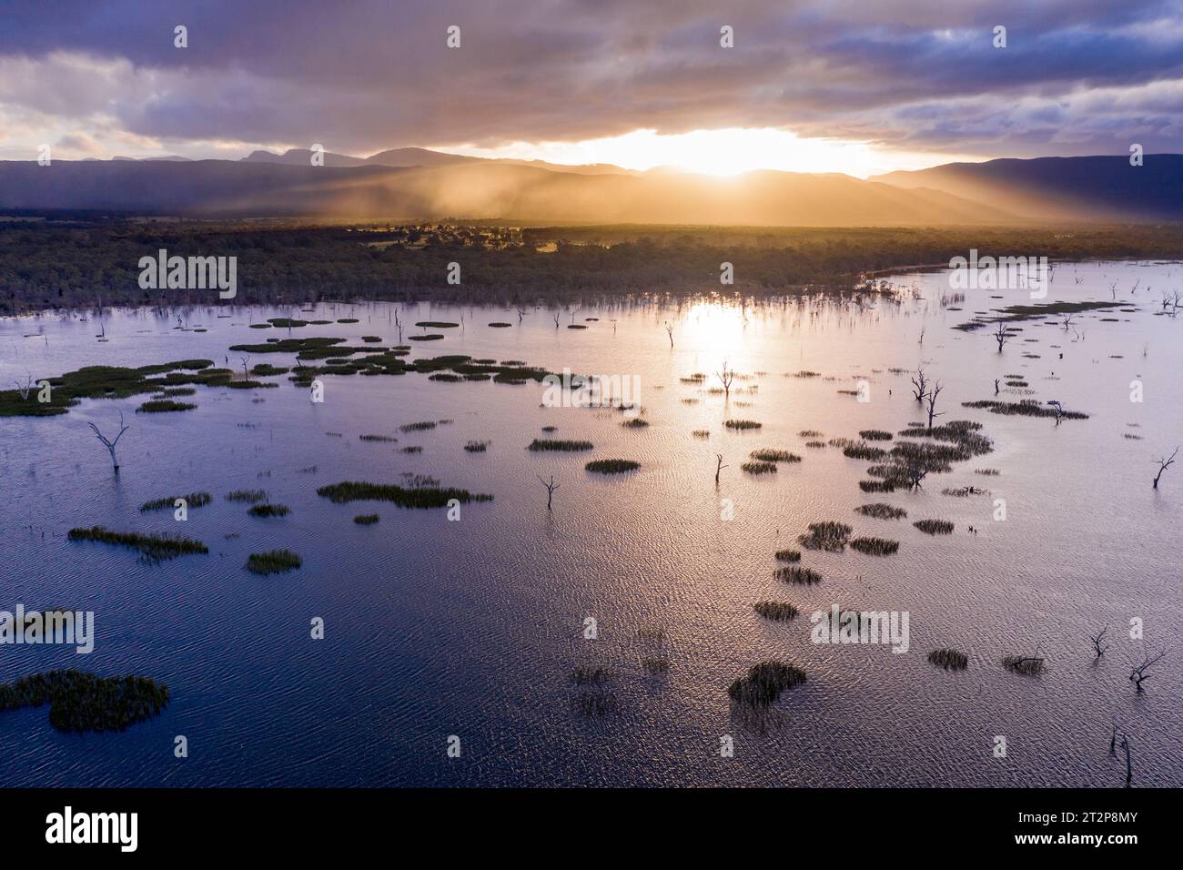 Aerial view of dramatic light breaking through clouds over a mountain ...