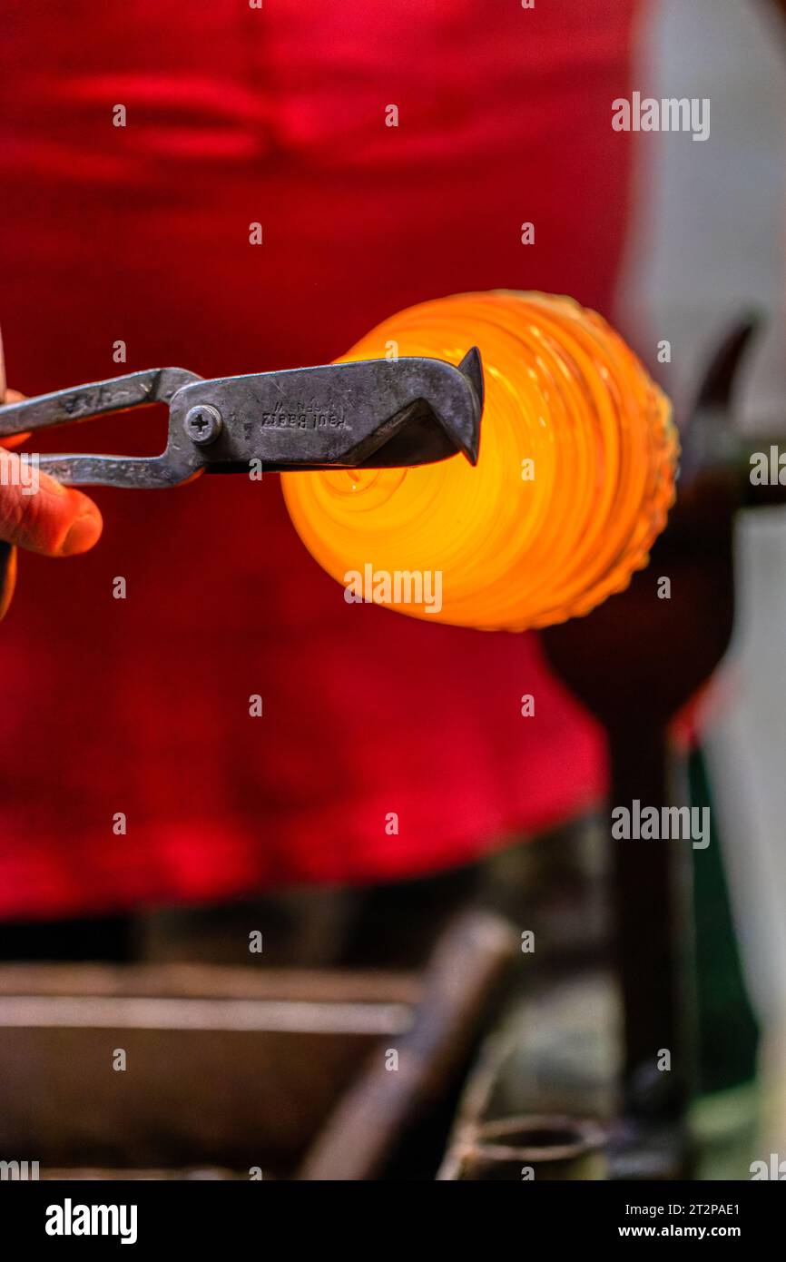 Glassblower shaping a glass, blowpipe Stock Photo - Alamy