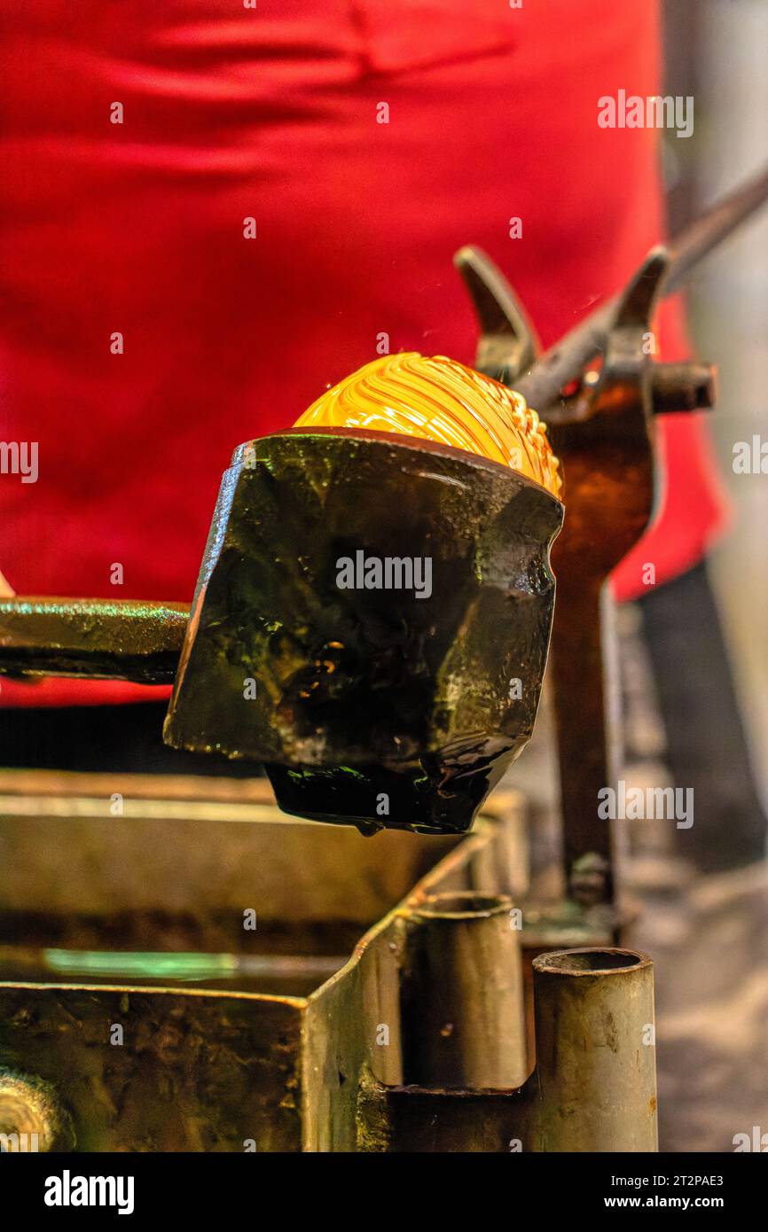 Glassblower shaping a glass, blowpipe Stock Photo - Alamy