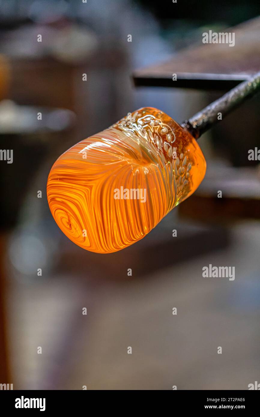 Glassblower shaping a glass, blowpipe Stock Photo - Alamy