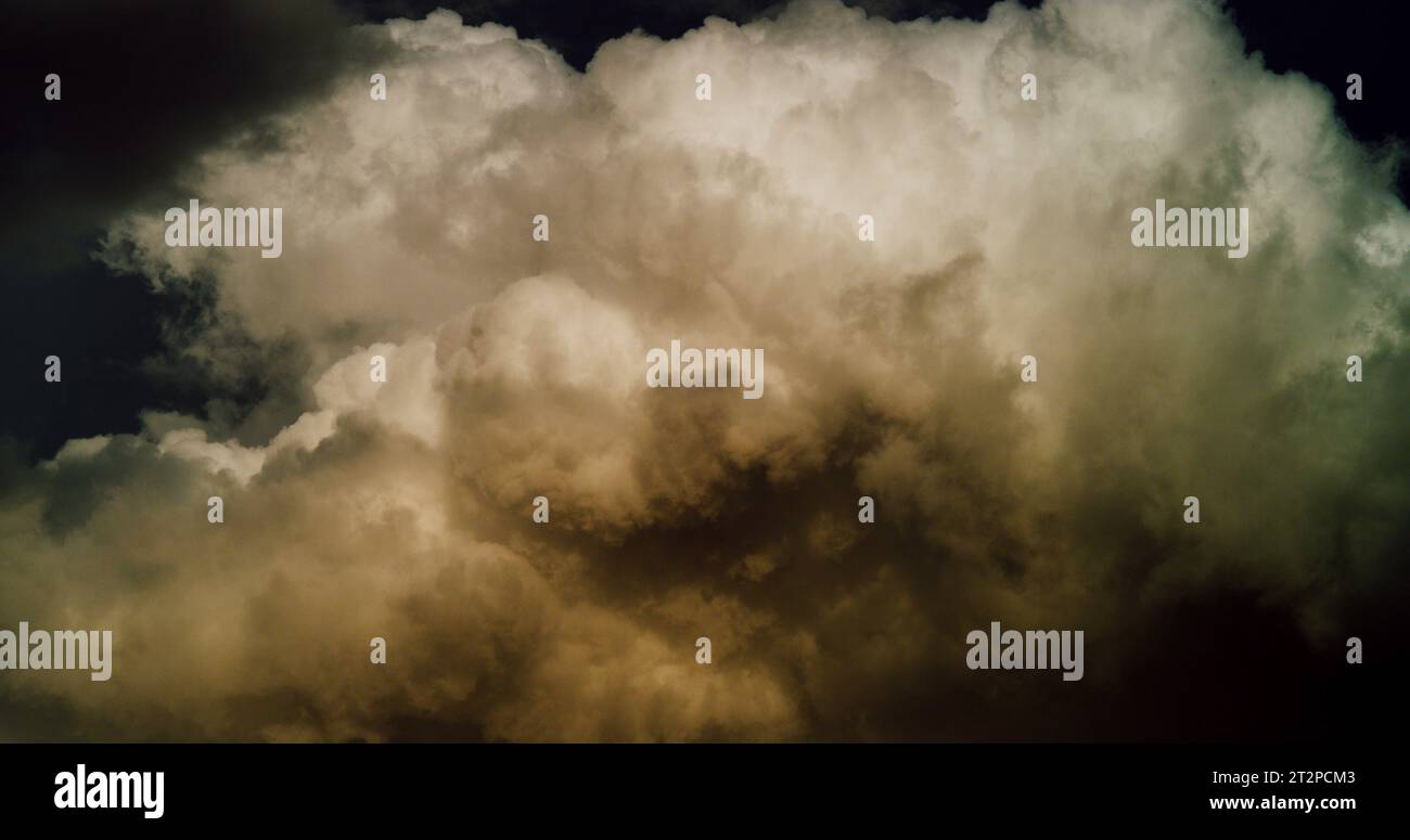 Evening storm clouds burst with light, texture, and deepening shadows ...