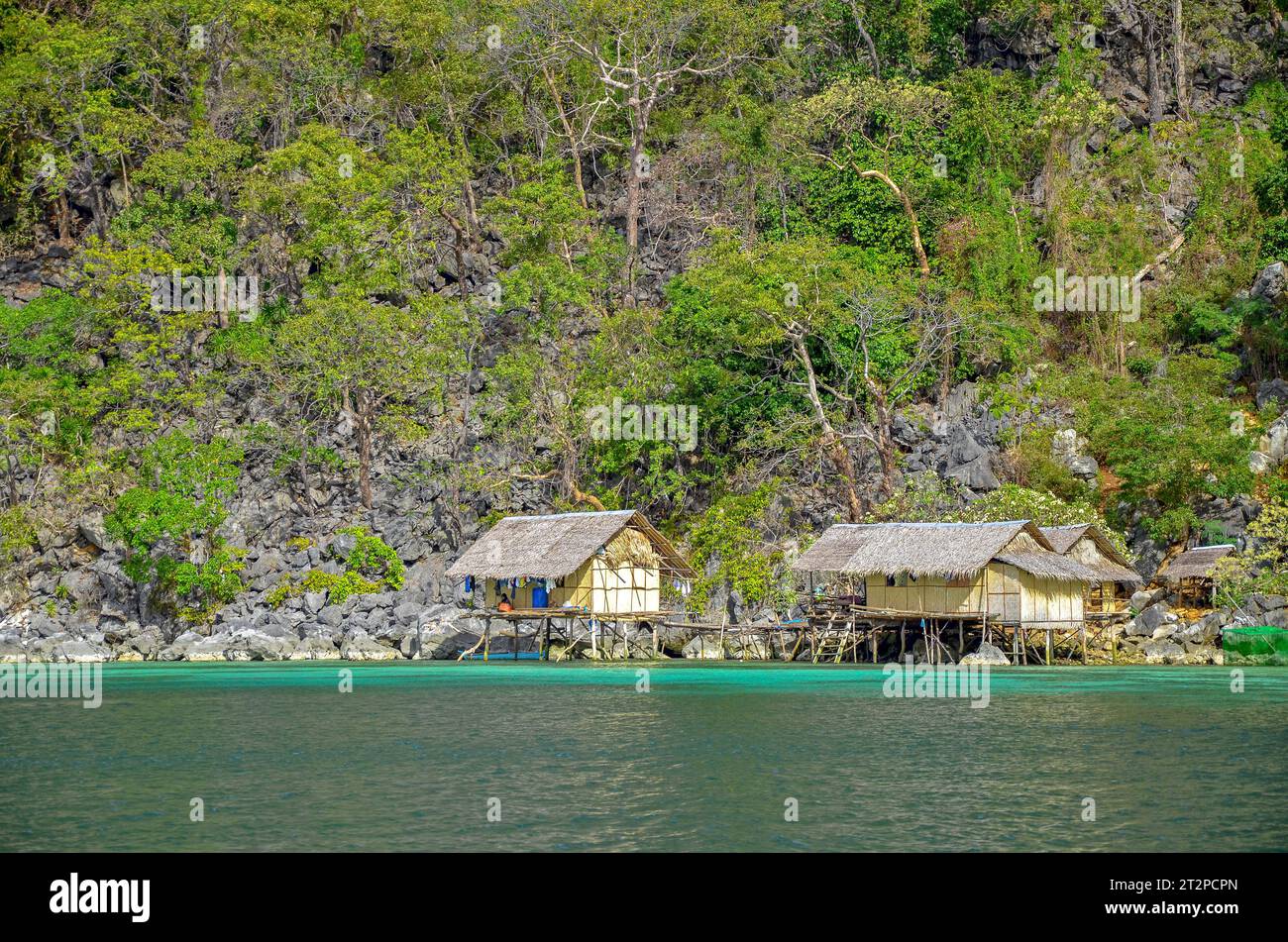 Unapproachable cliffs of Sangat Island and fishing huts by the sea ...