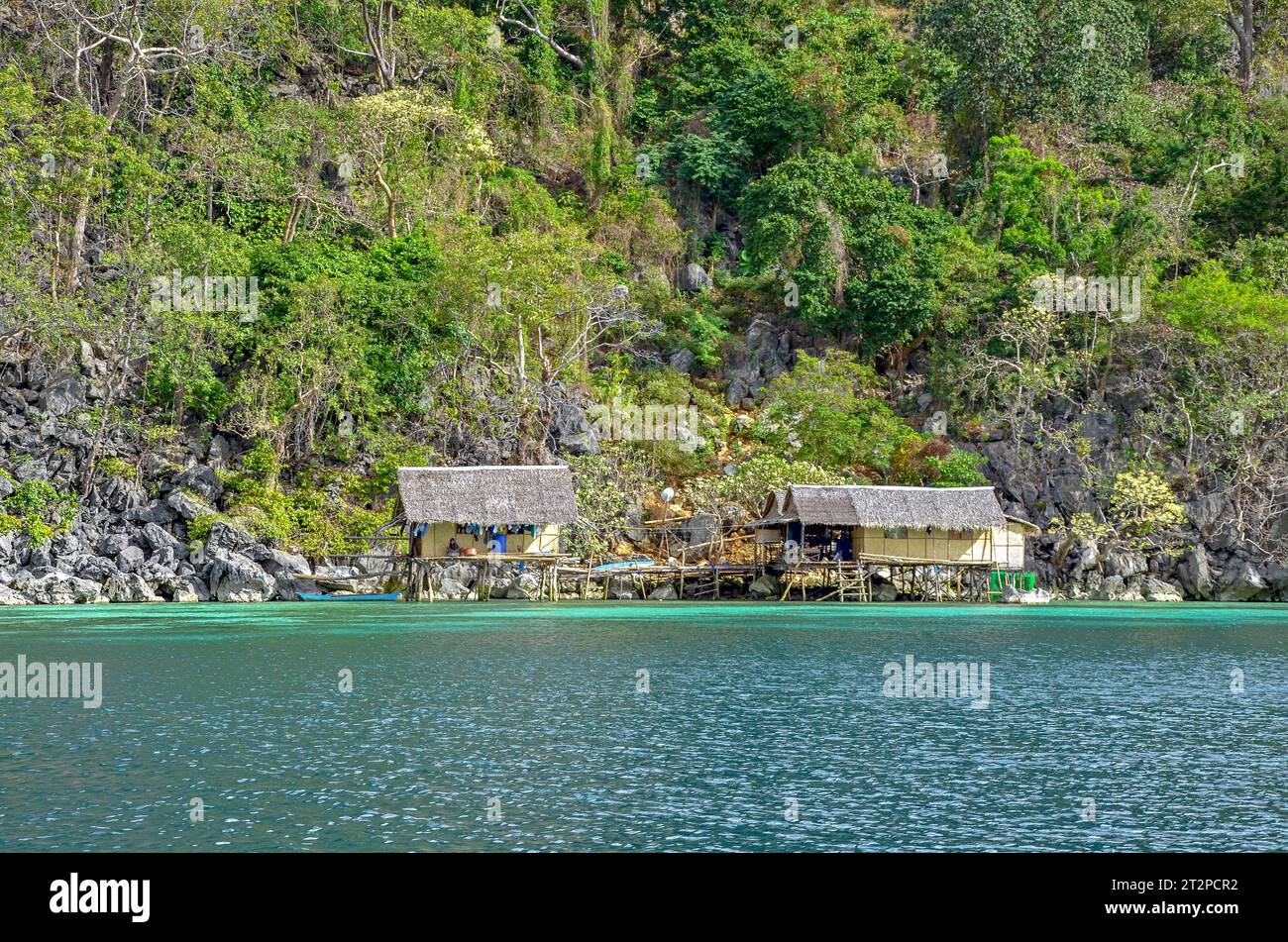 Unapproachable cliffs of Sangat Island and fishing huts by the sea ...