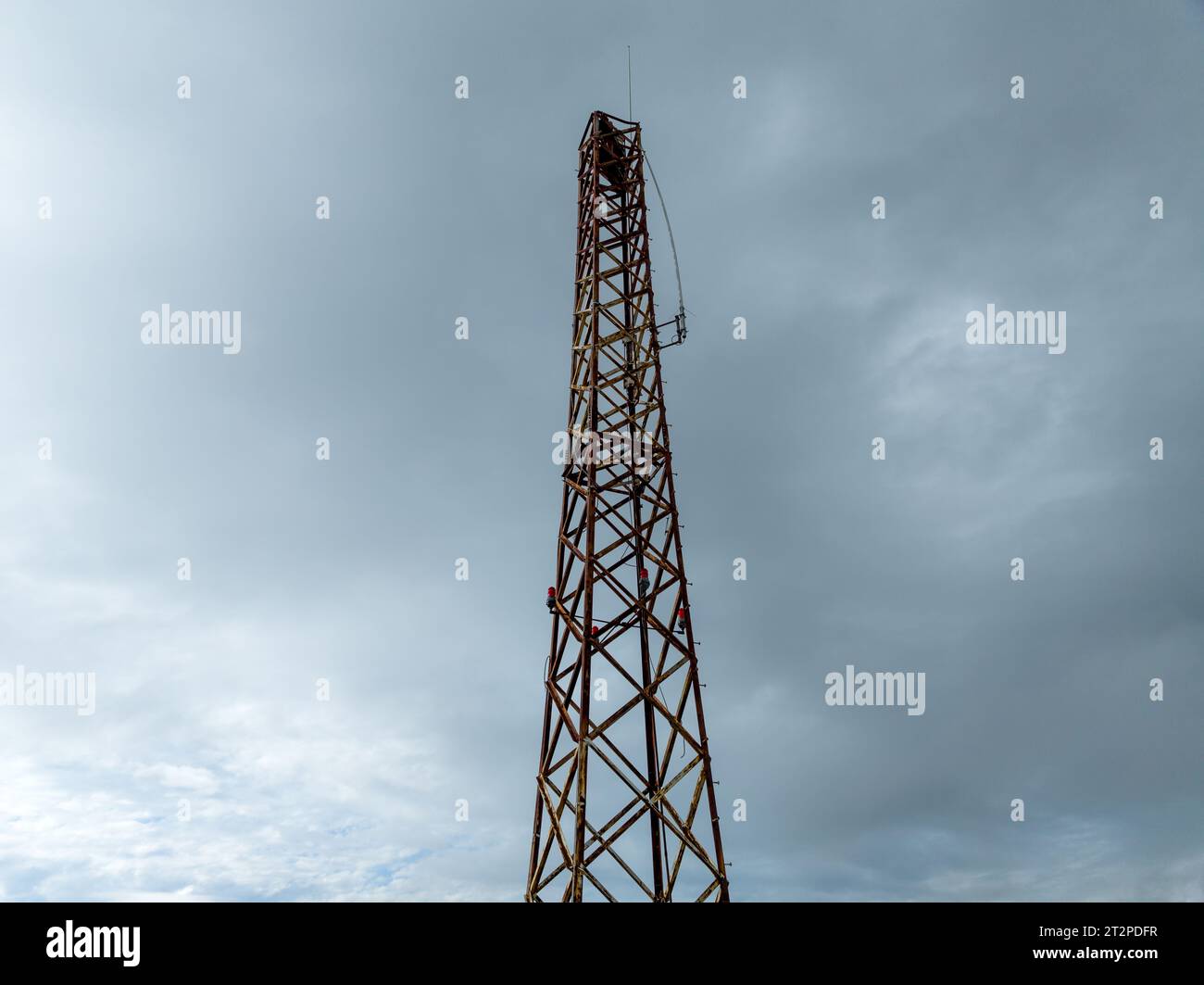 Old television and radio tower in faded colors with rusty structural ...