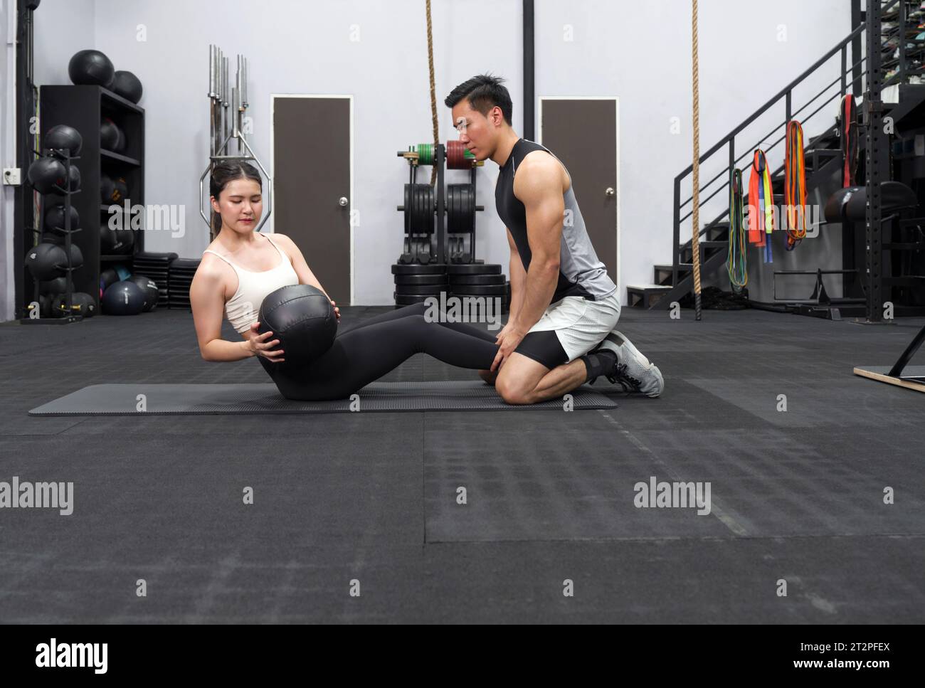 A fit couple engaging in a workout routine within a well-equipped gym ...