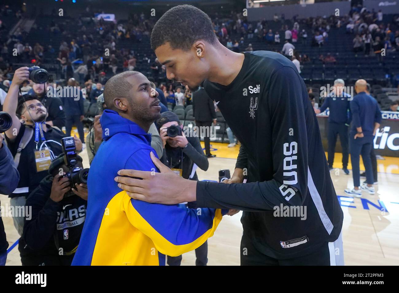 Golden State Warriors guard Chris Paul, left, greets San Antonio Spurs center Victor Wembanyama ...