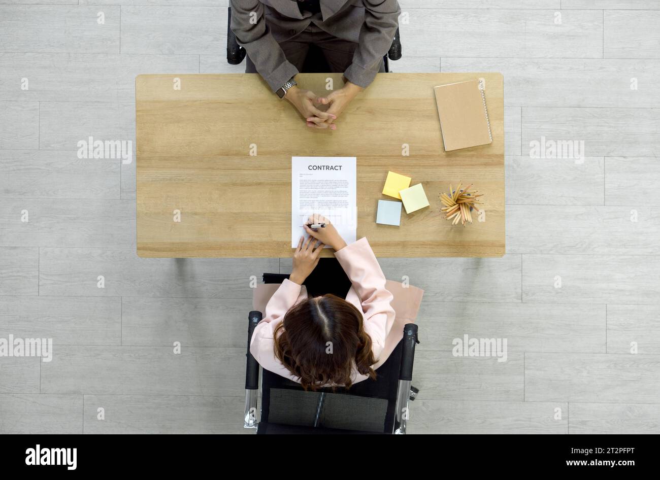 Young woman signing important document at a table. Professional ...