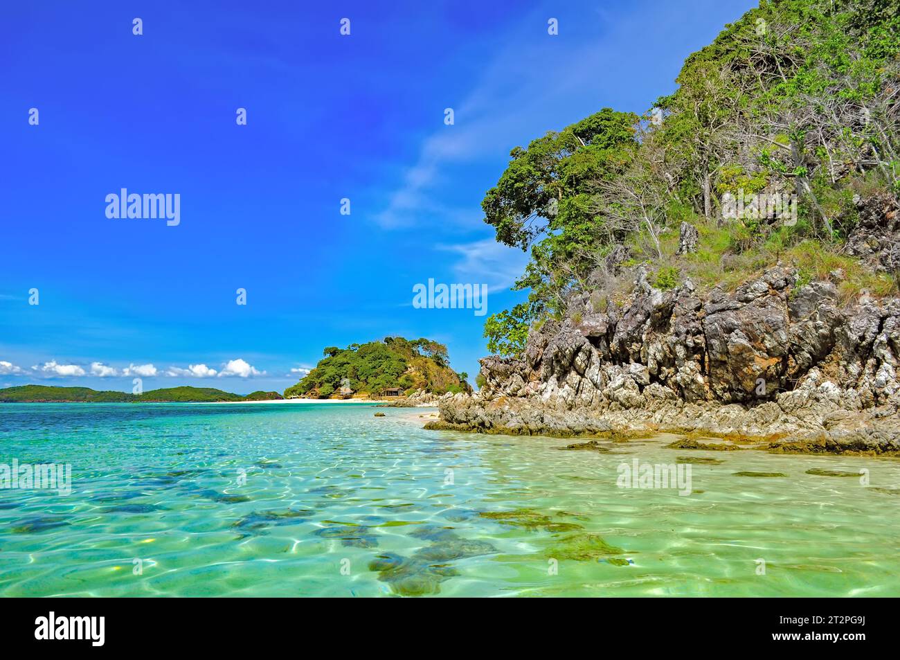 Stone rocks, overgrown with jungle and sea with clear azure water ...